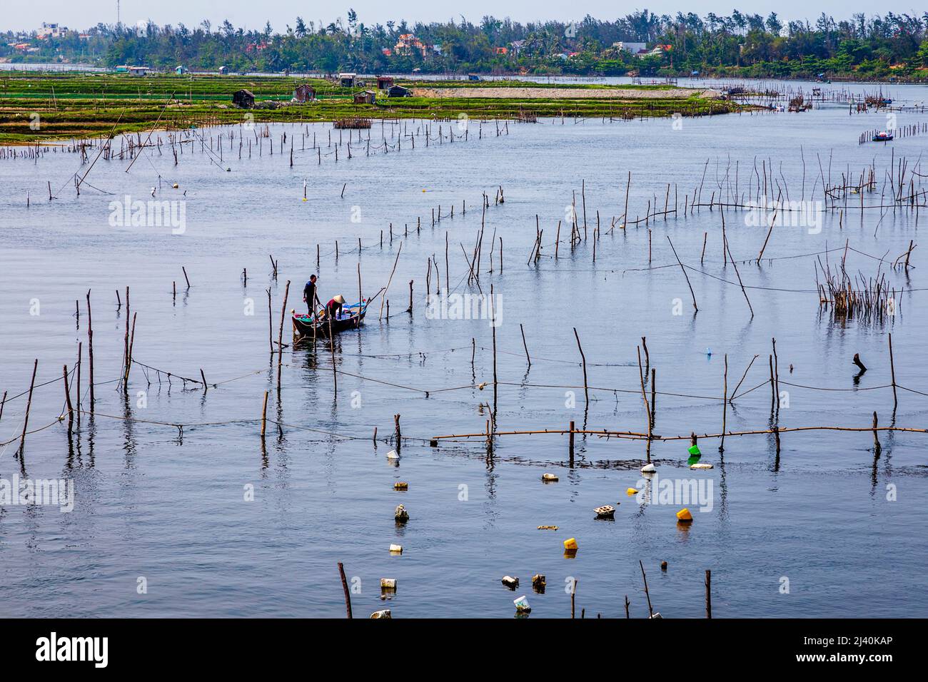 Two fishermen in a round boat out checking their nets for fish Stock ...
