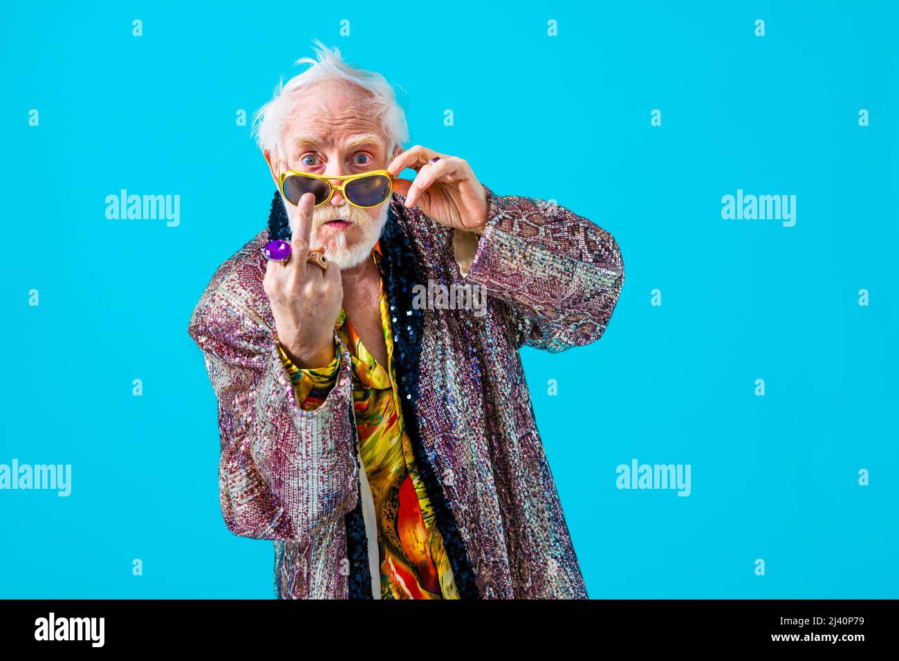 Cool senior man with fashionable clothing style portrait on colored ...