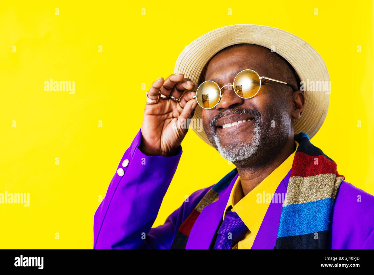 Cool senior man with fashionable clothing style portrait on colored ...