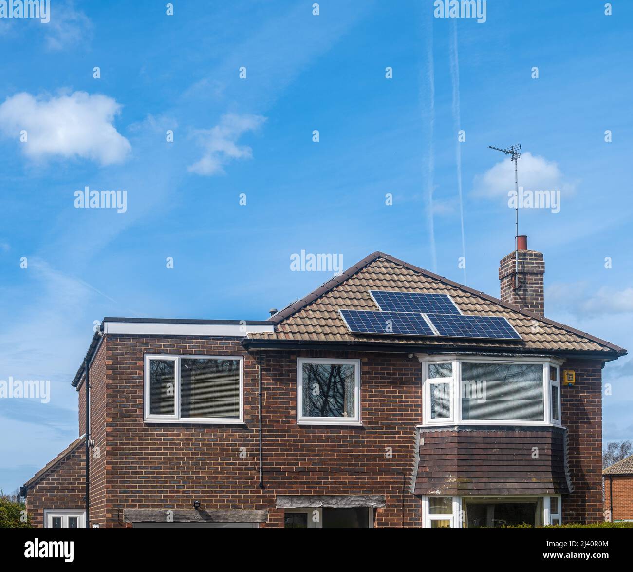 Three photovoltaic solar panels on the roof of a detached house for ...