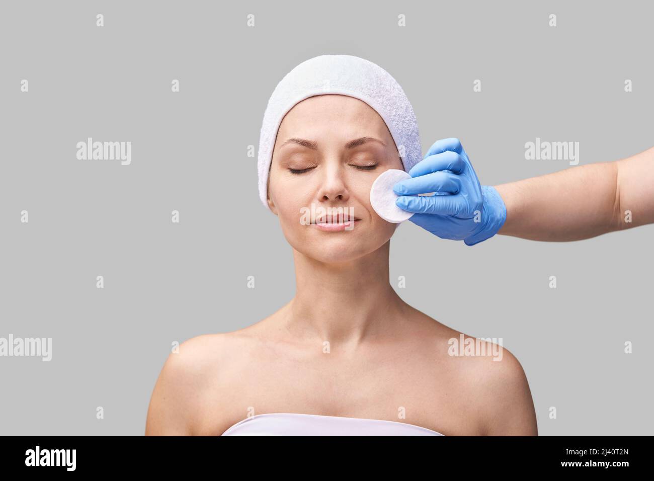 Pure skin care mature beauty portrait. Demakeup using cotton pad ...