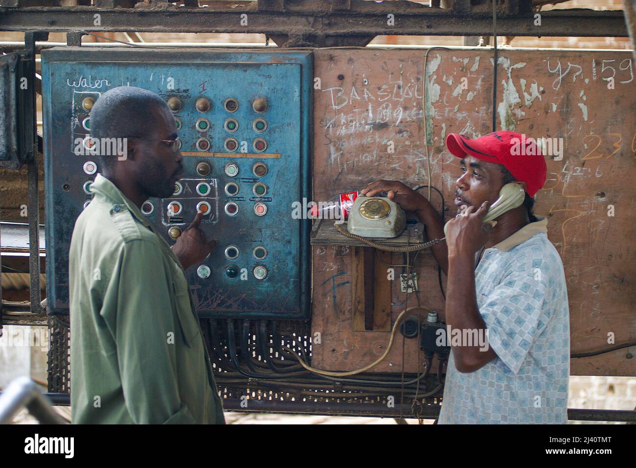 Surinam, Paramaribo - Employees at the saw mill of a timber factory at a switchboard to control ...