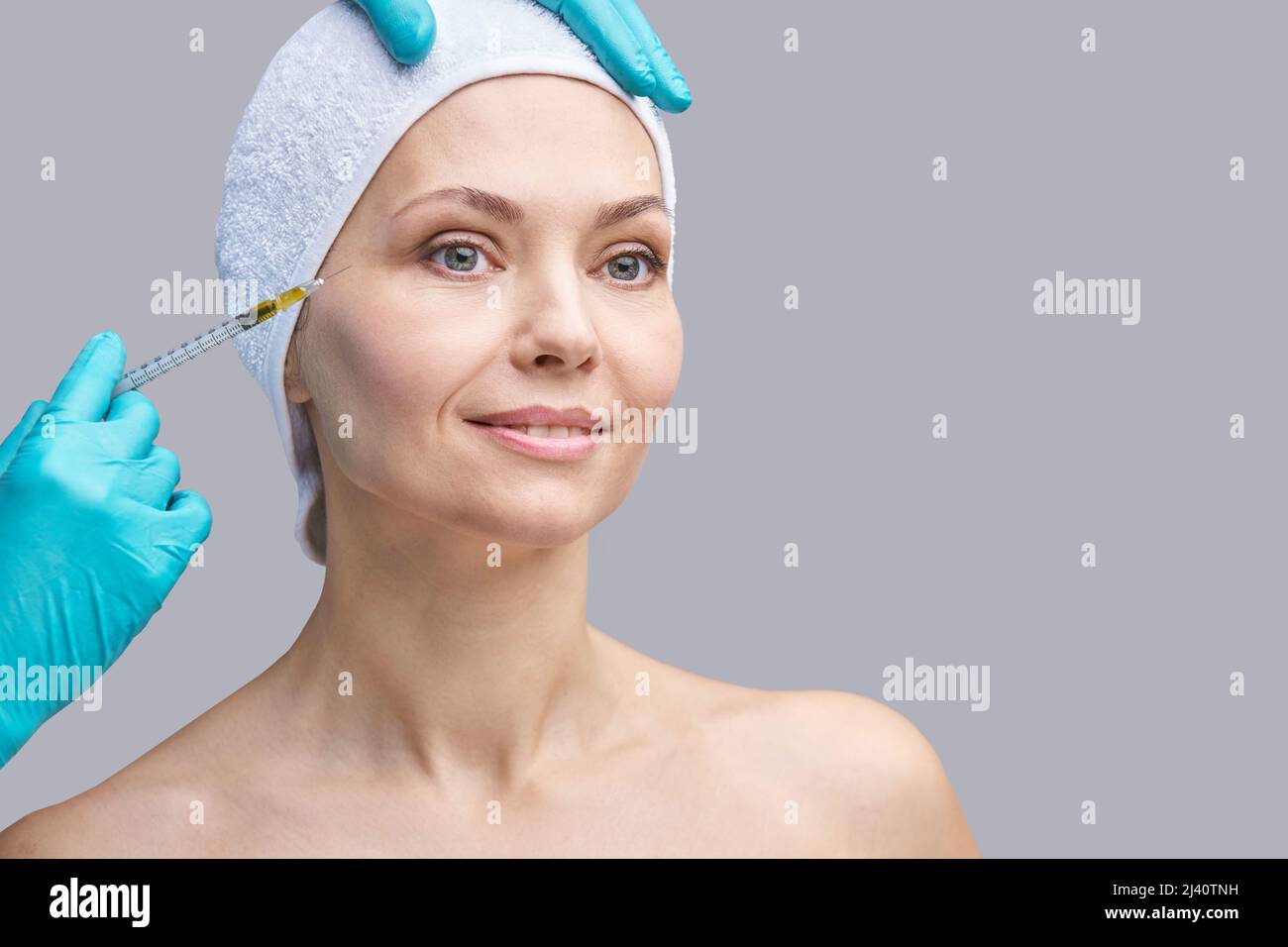 Face needle injection. Young woman cosmetology procedure. Doctor hand ...