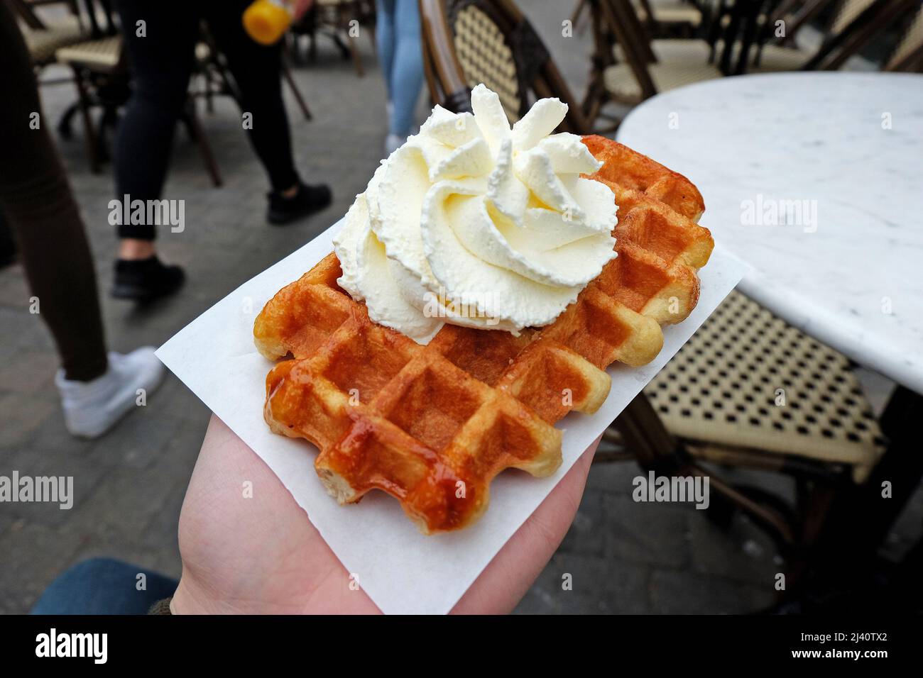 Hand holding Whipped cream on classic butter Waffle dessert Stock Photo ...