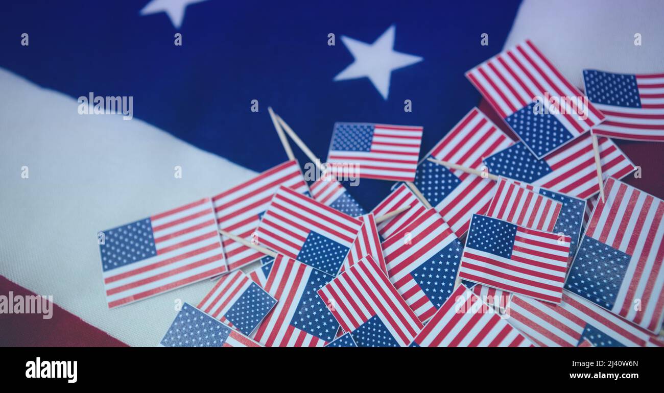 Multiple miniature american flags against american flag in background ...