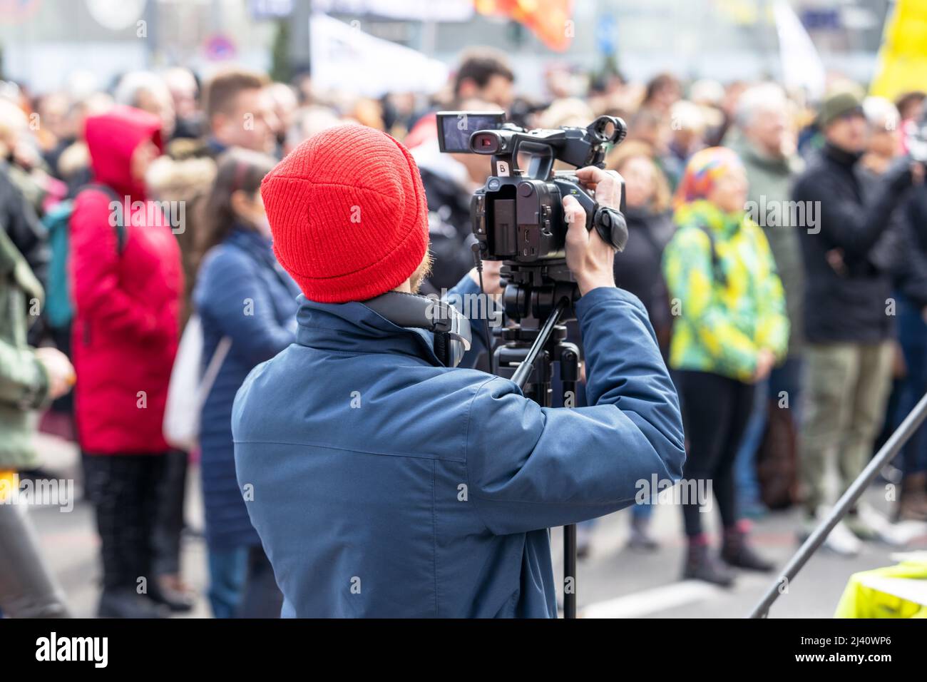 Shooting protest, television camera operator in the focus, blurred ...