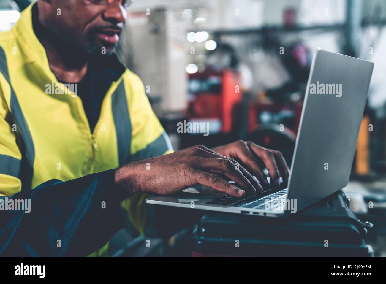Factory worker working with laptop computer to do adept procedure ...