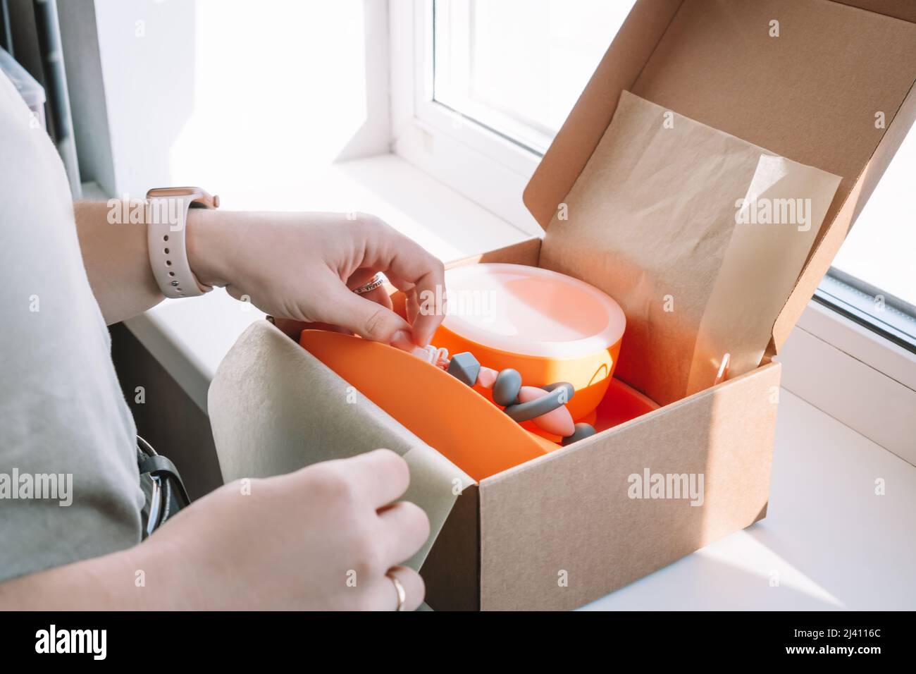Cropped image of woman hands packing shipment with silicone kids dishes ...