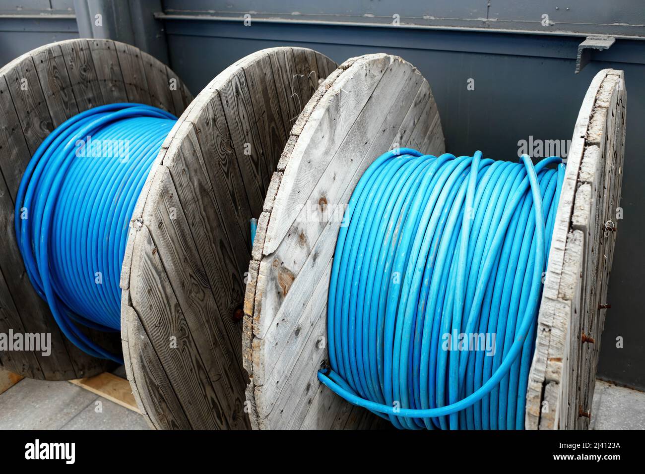 New blue power cable is wound on wooden coil. Background. Cable for ...