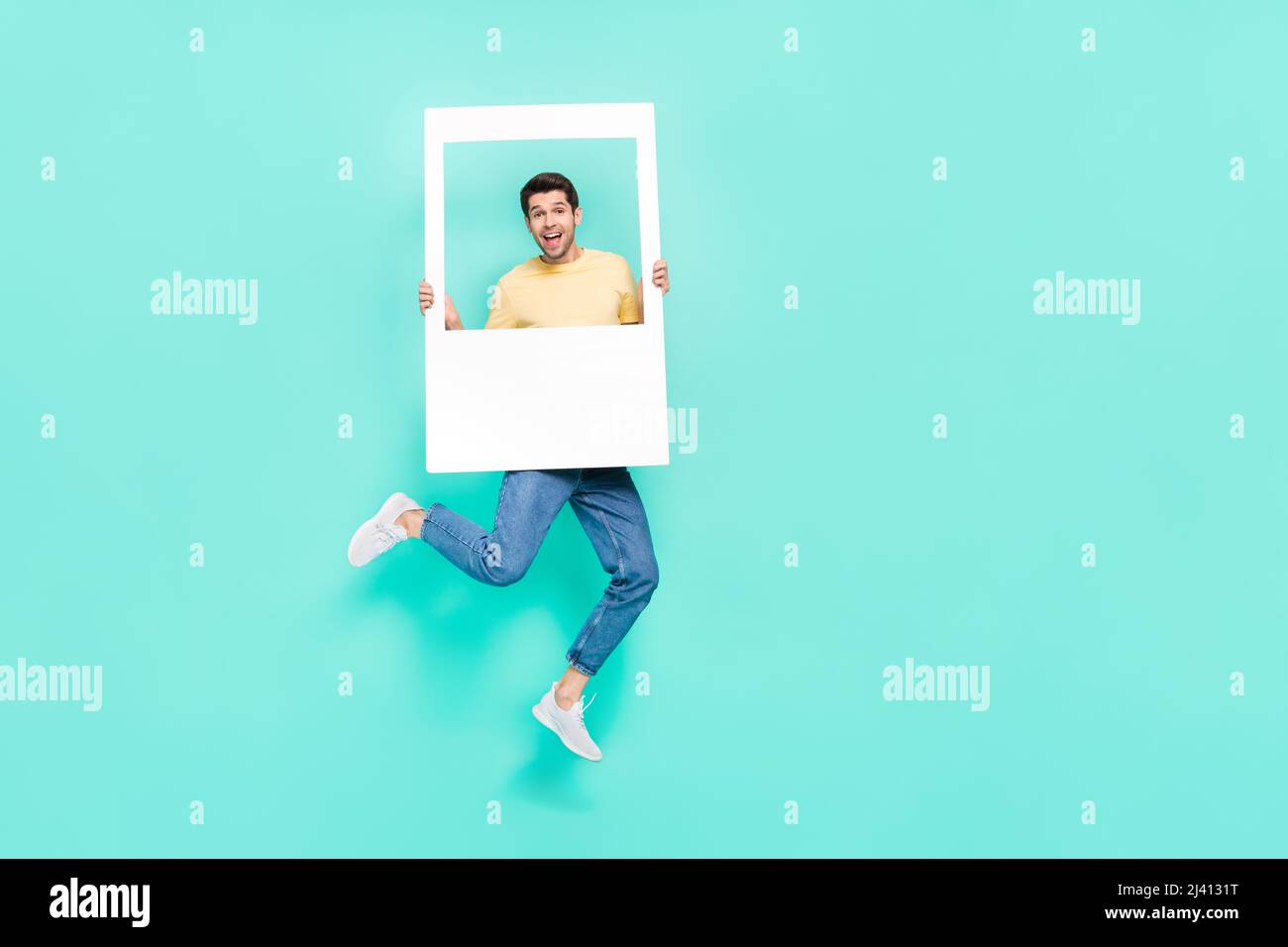 Full length portrait of overjoyed childish man hold paper card window ...