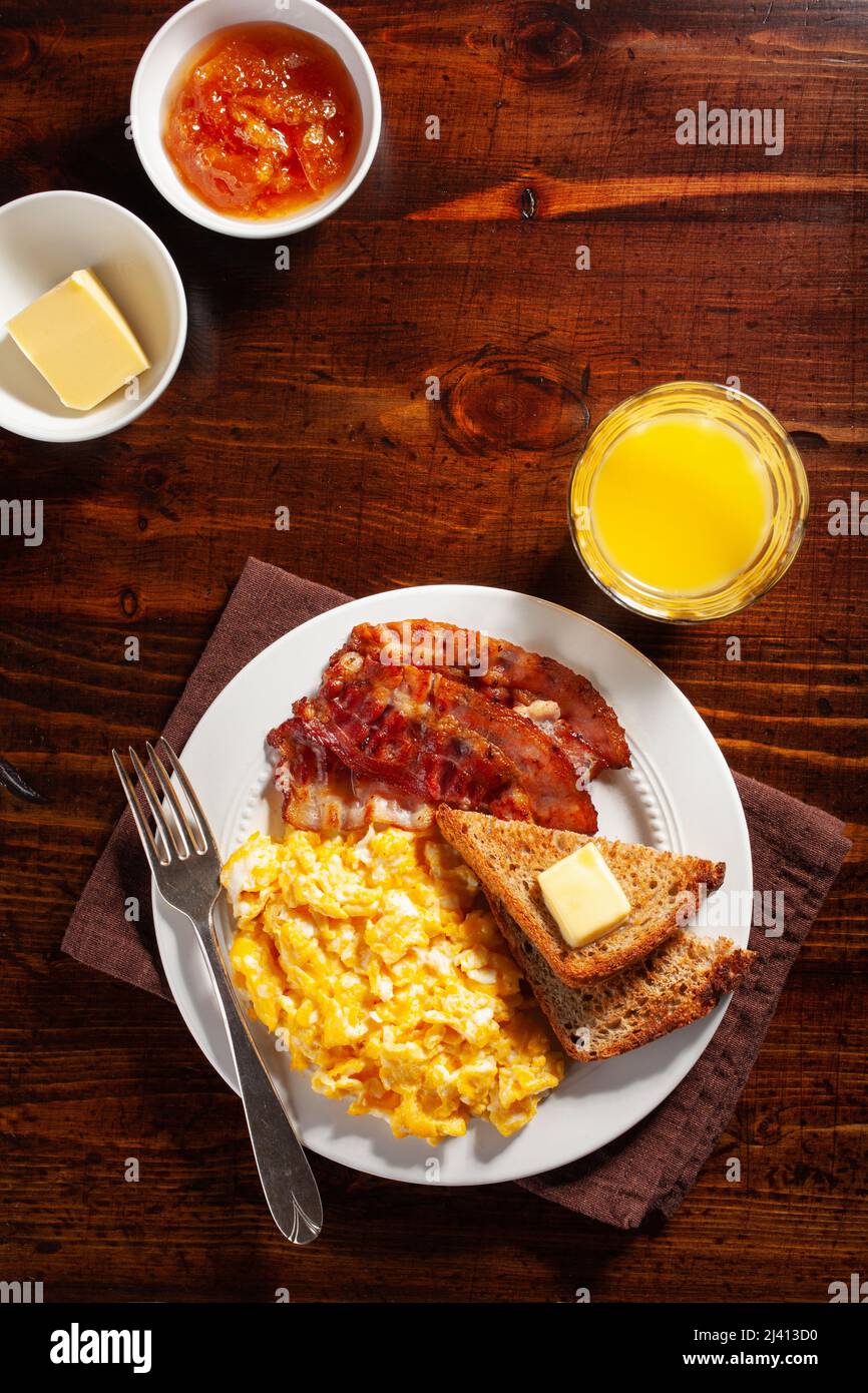 traditional scrambled egg breakfast with bacon and toast Stock Photo - Alamy
