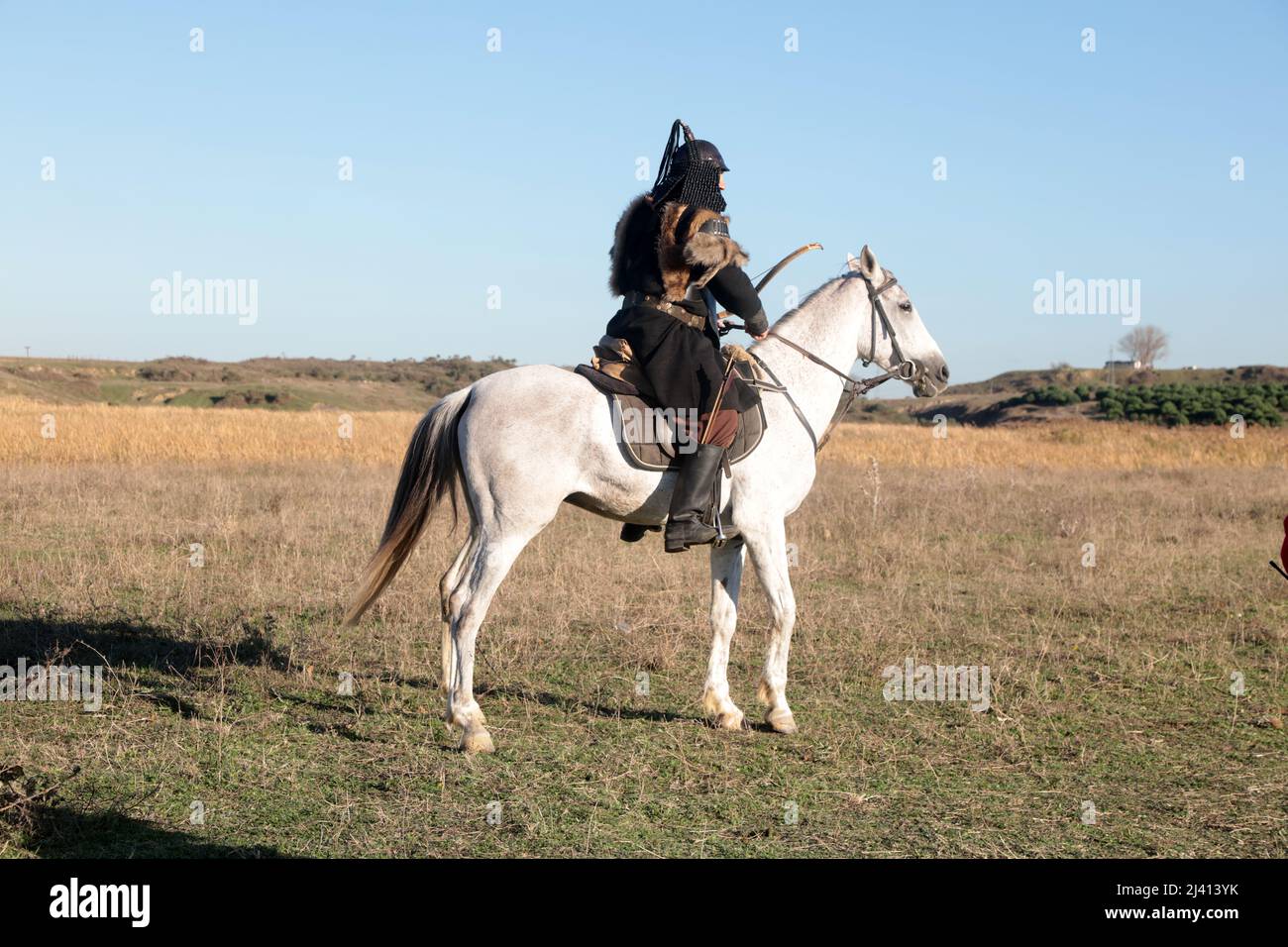 A Turkish soldier in traditional clothing is riding a white horse. An ...