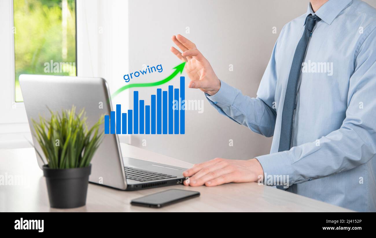 Business man holding holographic graphs and stock market statistics ...