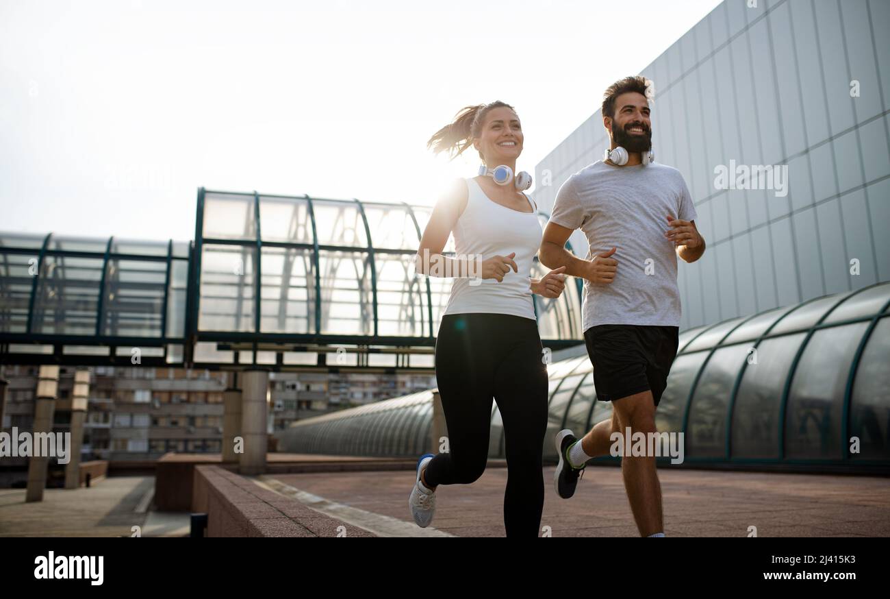 Happy runner couple exercising outside as part of healthy lifestyle ...