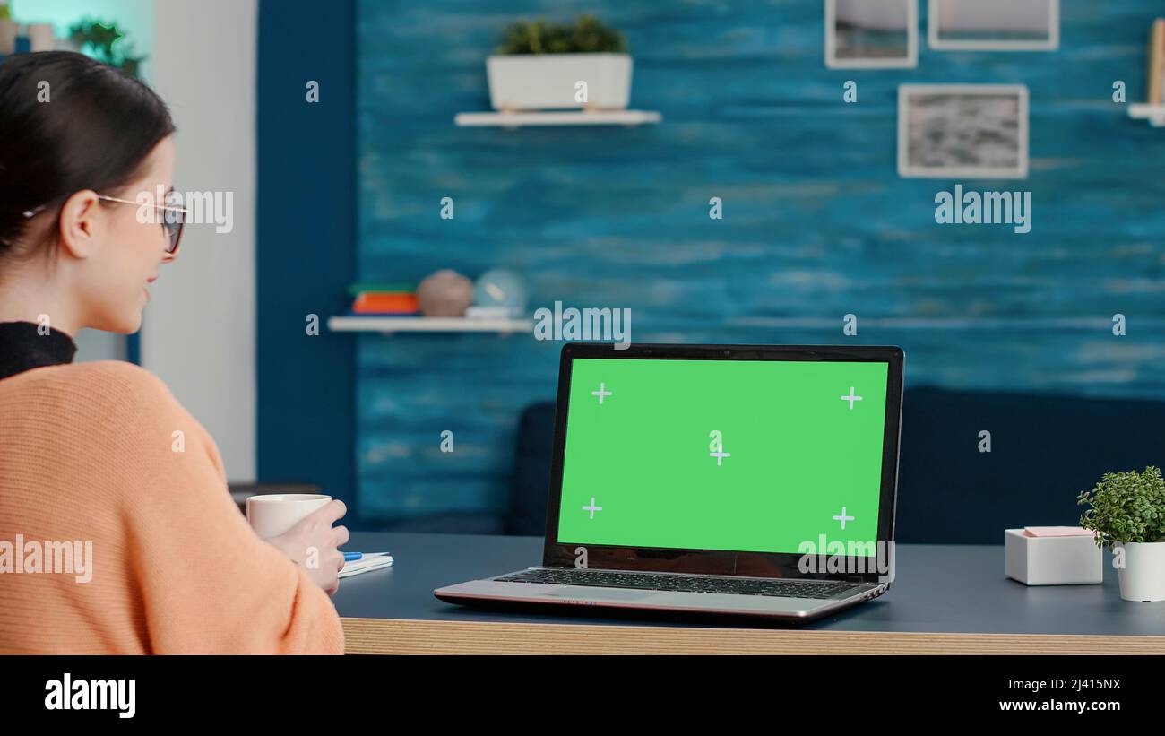 Young student looking at green screen on laptop computer, studying for ...