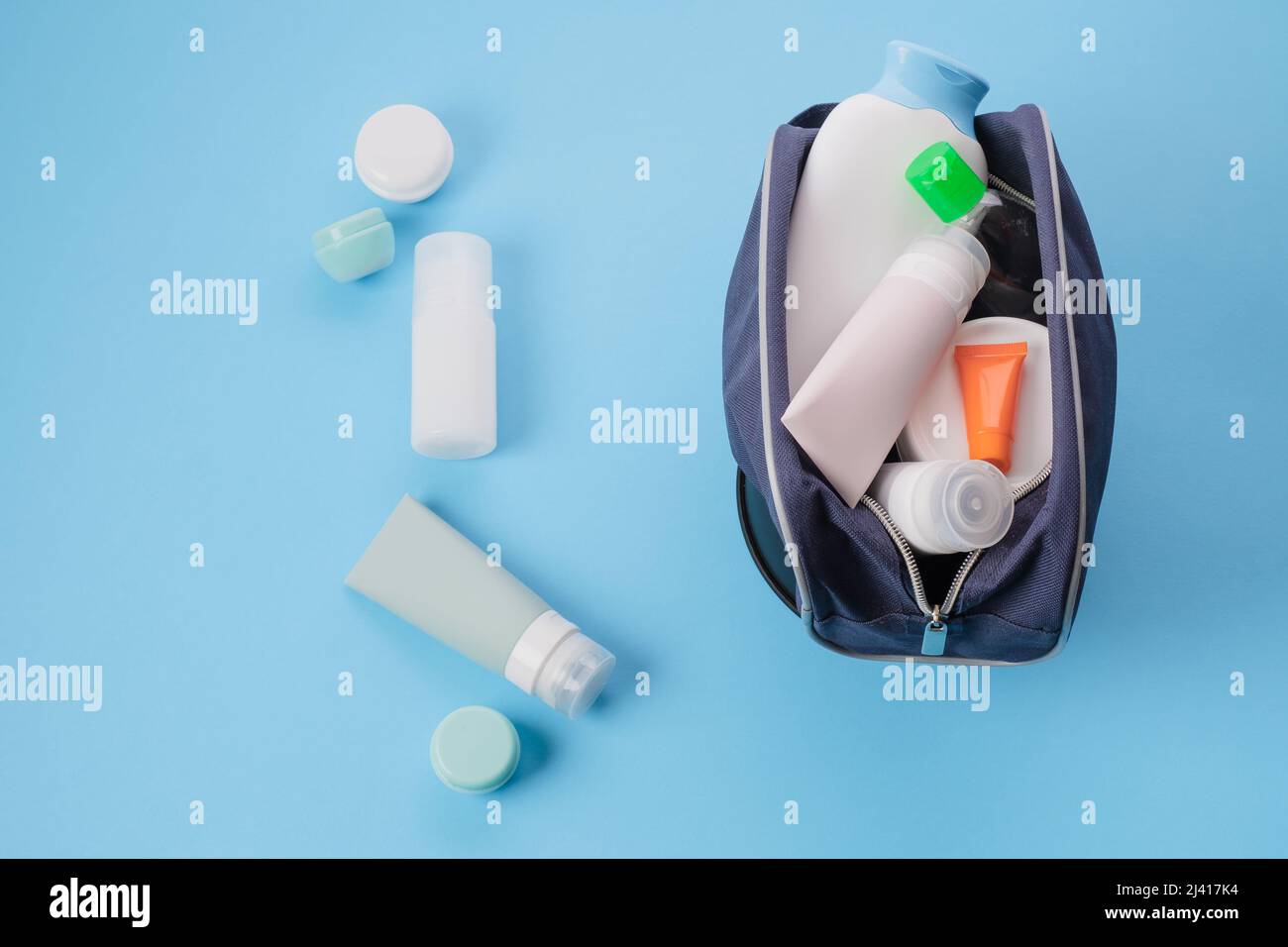 Cosmetic products in a makeup bag for recycling on blue background ...