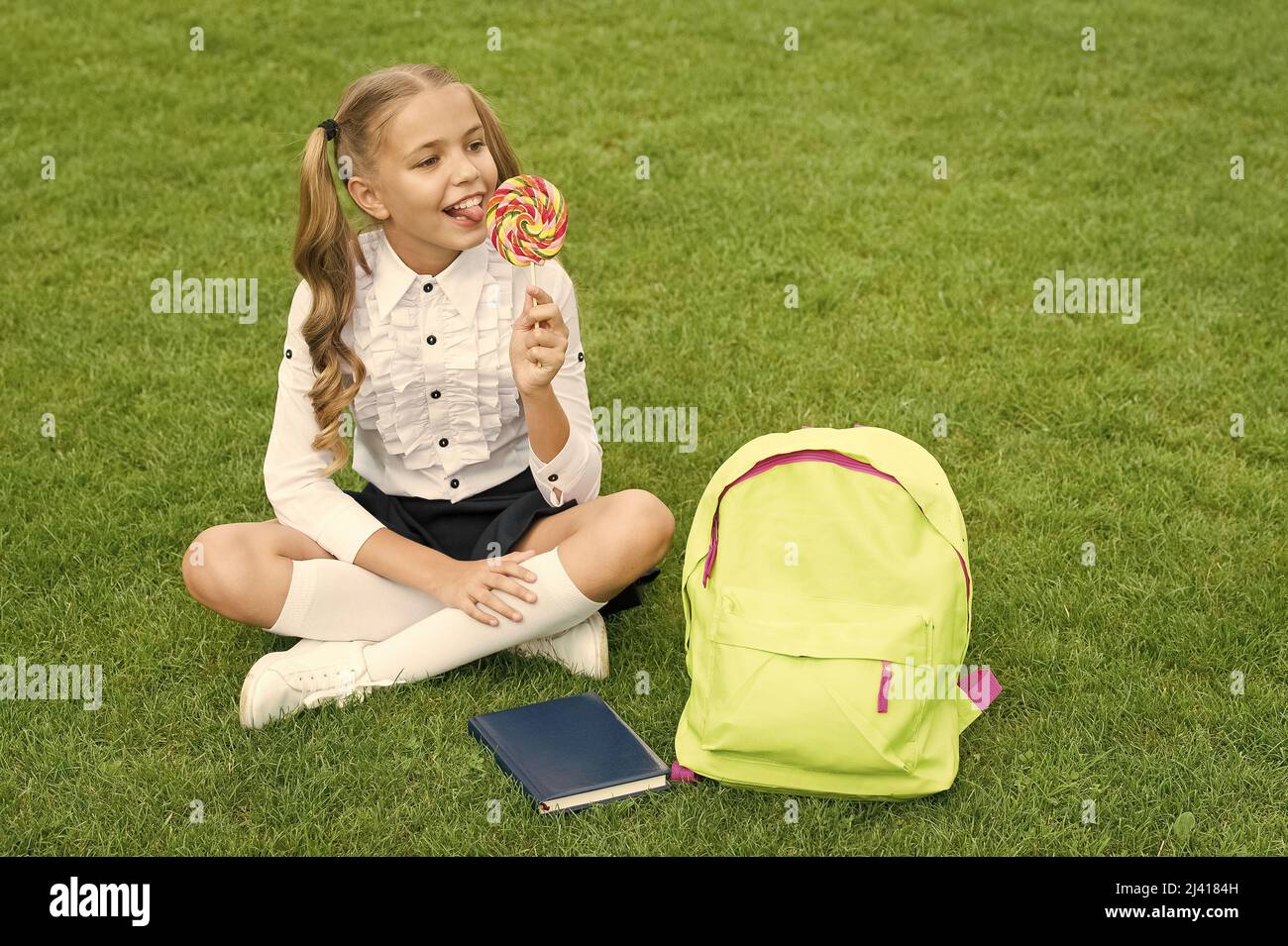 Candy kid. Happy schoolchild enjoy lollipop. Sweet tooth. Candy eating ...
