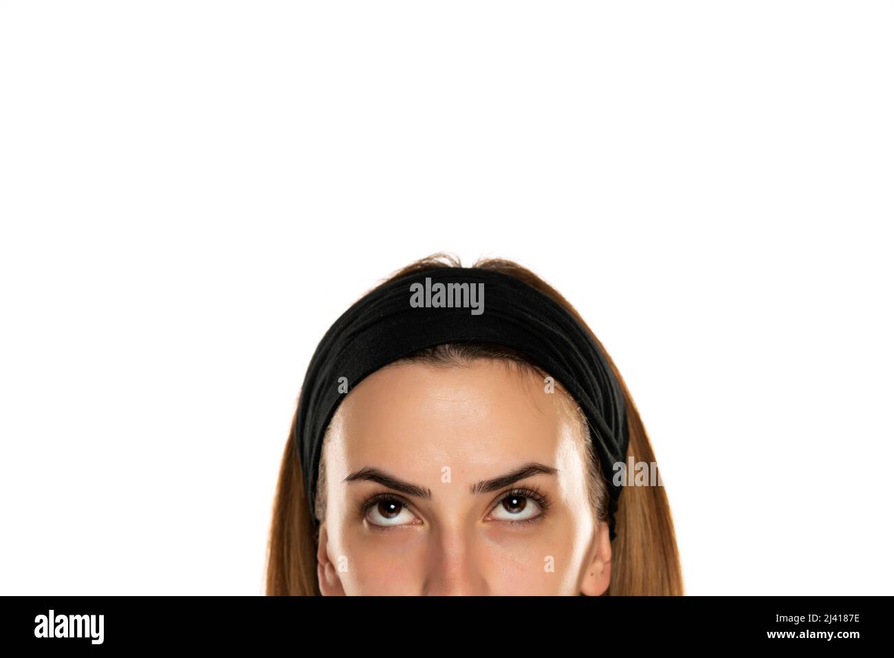 half portrait of a young girl with headband looking up on white ...