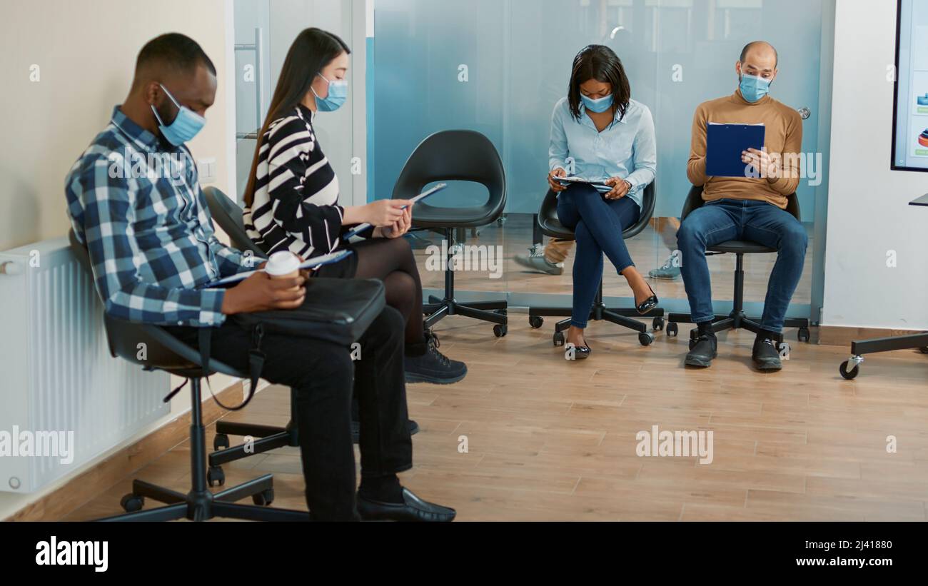 Multiethnic applicants waiting in lobby to enter job interview meeting ...