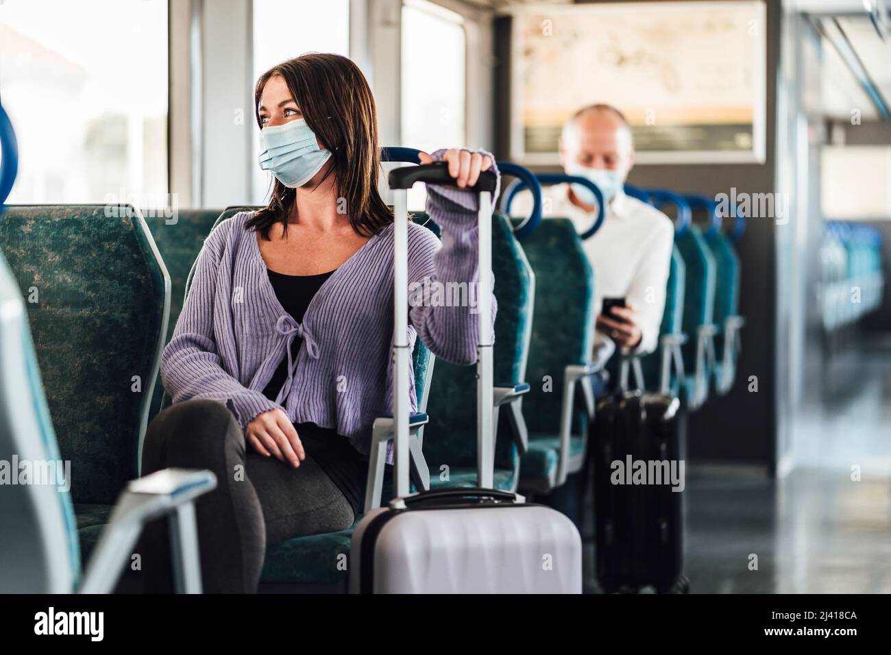 Serious passengers in protective masks during their train day trip ...