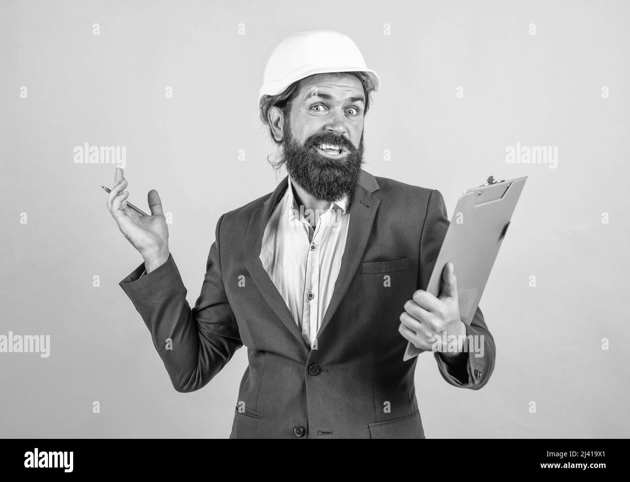 brutal unshaven guy in formal wear and hard hat on building site ...