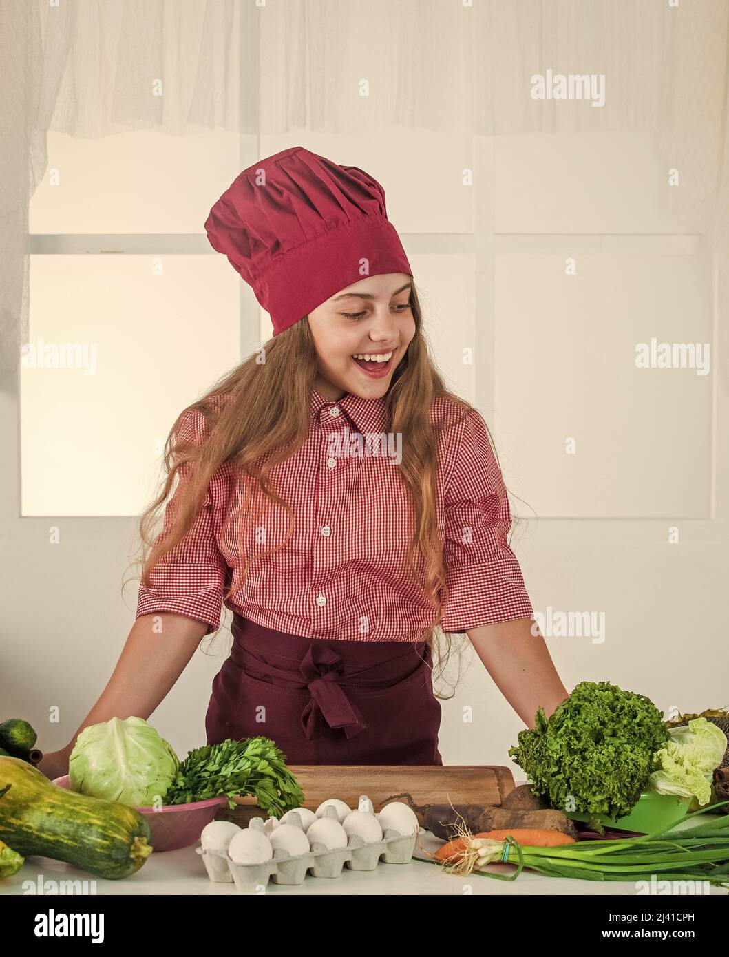 happy teen girl cooking vegetables. kid wearing professional chef ...