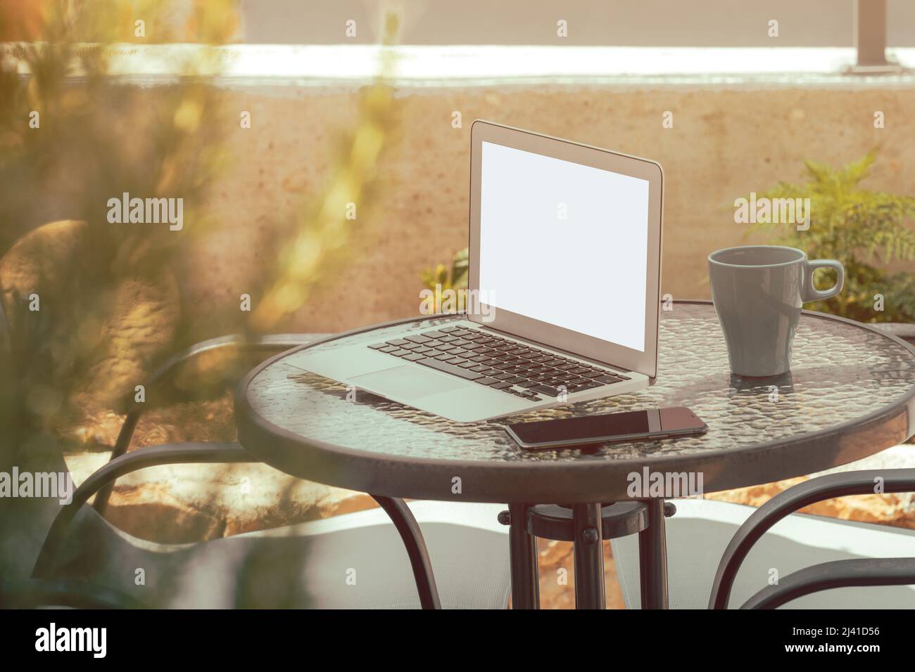 Laptop mockup screen on home balcony in summer morning, coffee cup on ...