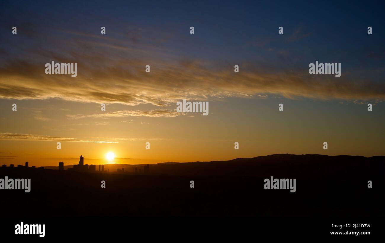 Colorful sky and distant city panorama at sunrise Stock Photo - Alamy