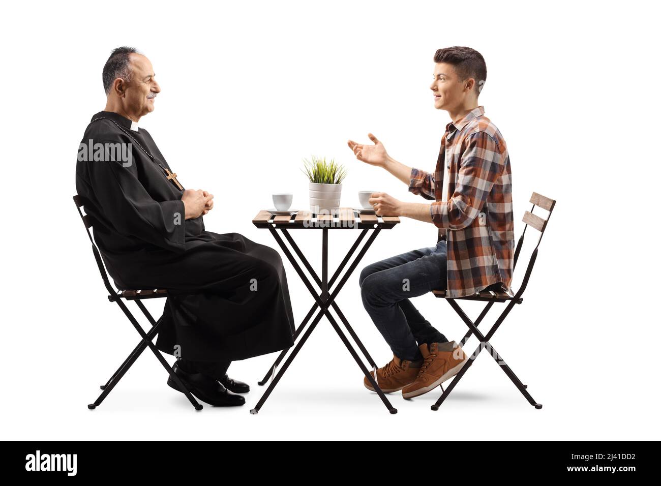 Young man sitting at a cafe table and talking to a priest isolated on ...