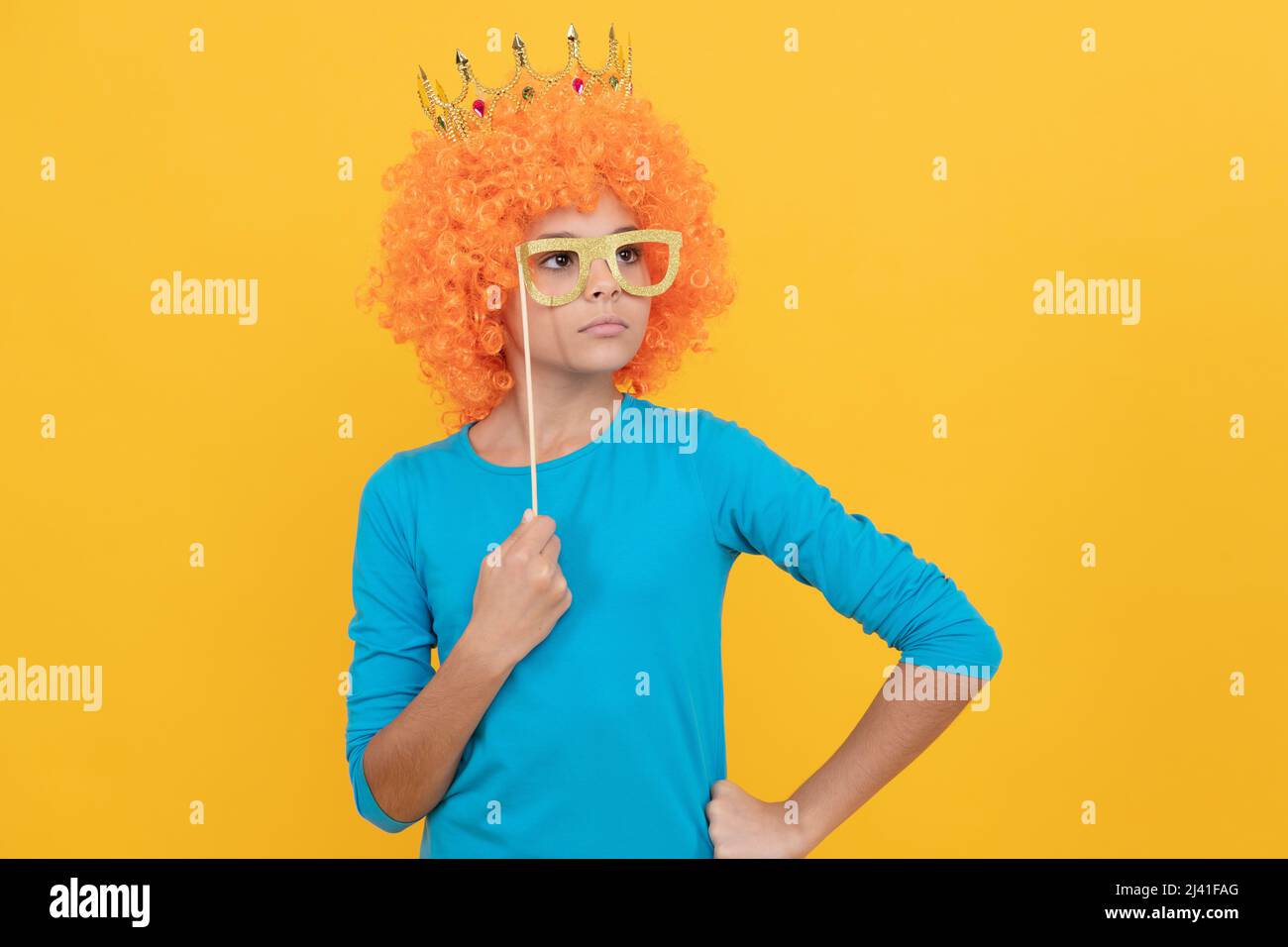 serious teen girl in fancy clown wig wear queen crown and funny party ...