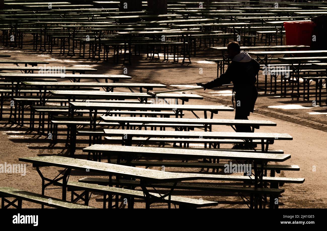 Munich, Germany. 11th Apr, 2022. A man cleans the wet tables and ...