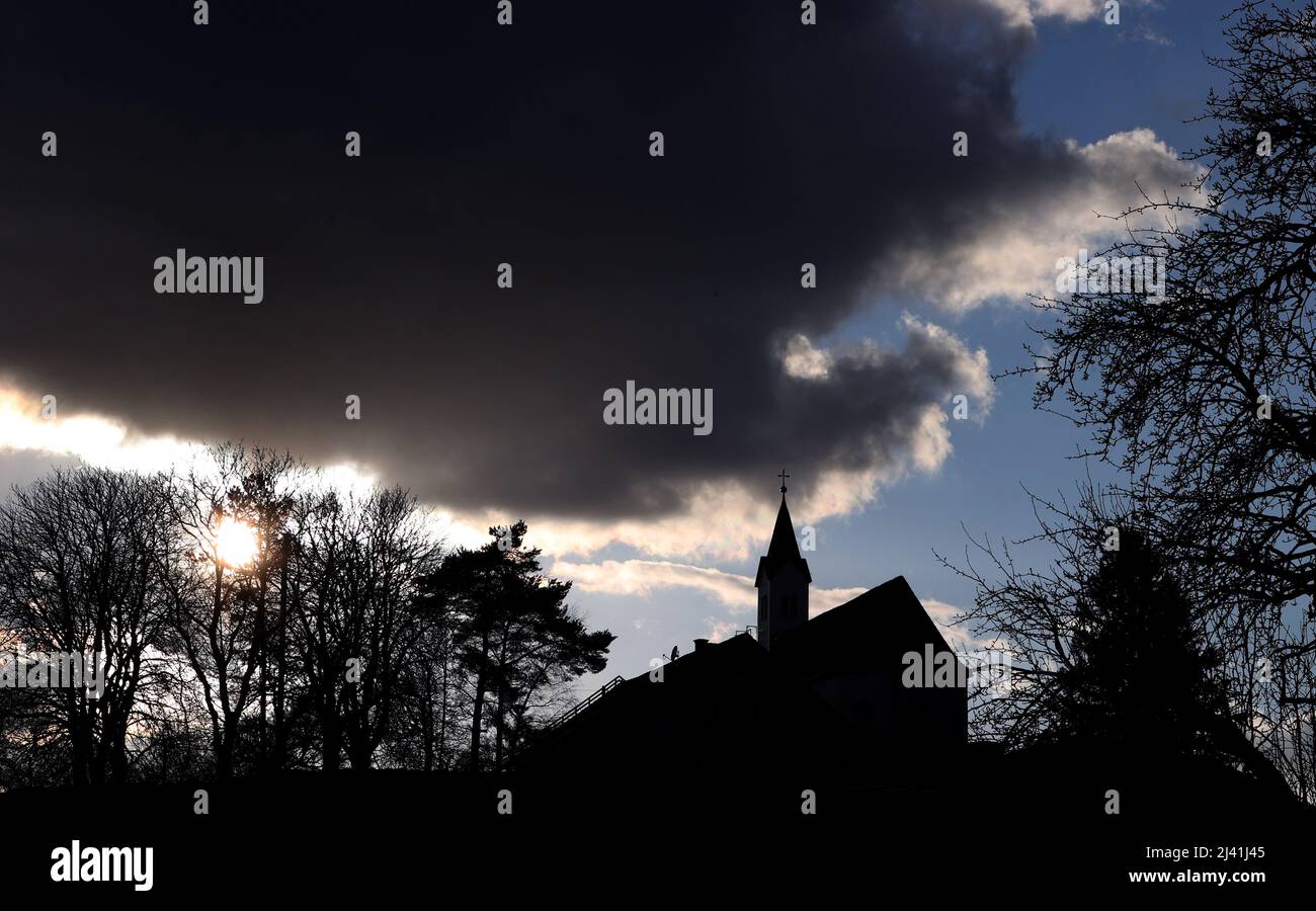 09 April 2022, Bavaria, Aitrang: In front of a gathering clouds stands ...