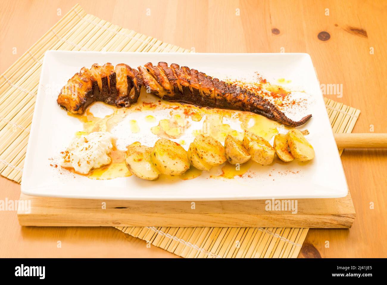Typical Spanish food, grilled octopus with potatoes and aioli sauce and ...