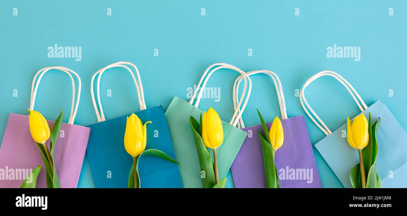 Flat lay blue background with flowers and paper bags Stock Photo - Alamy
