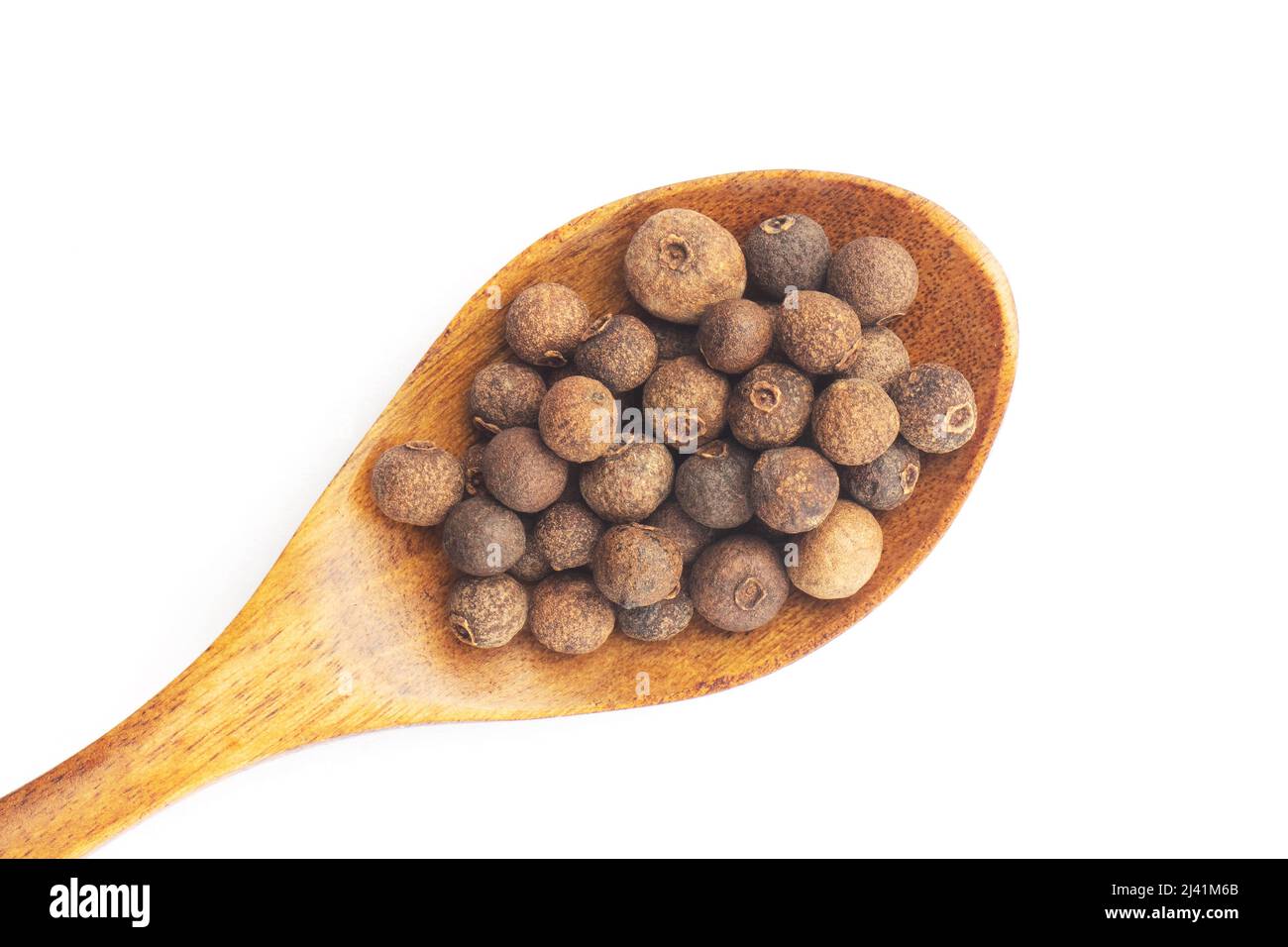 Spice Allspice in brown wooden spoon diagonally on white background ...