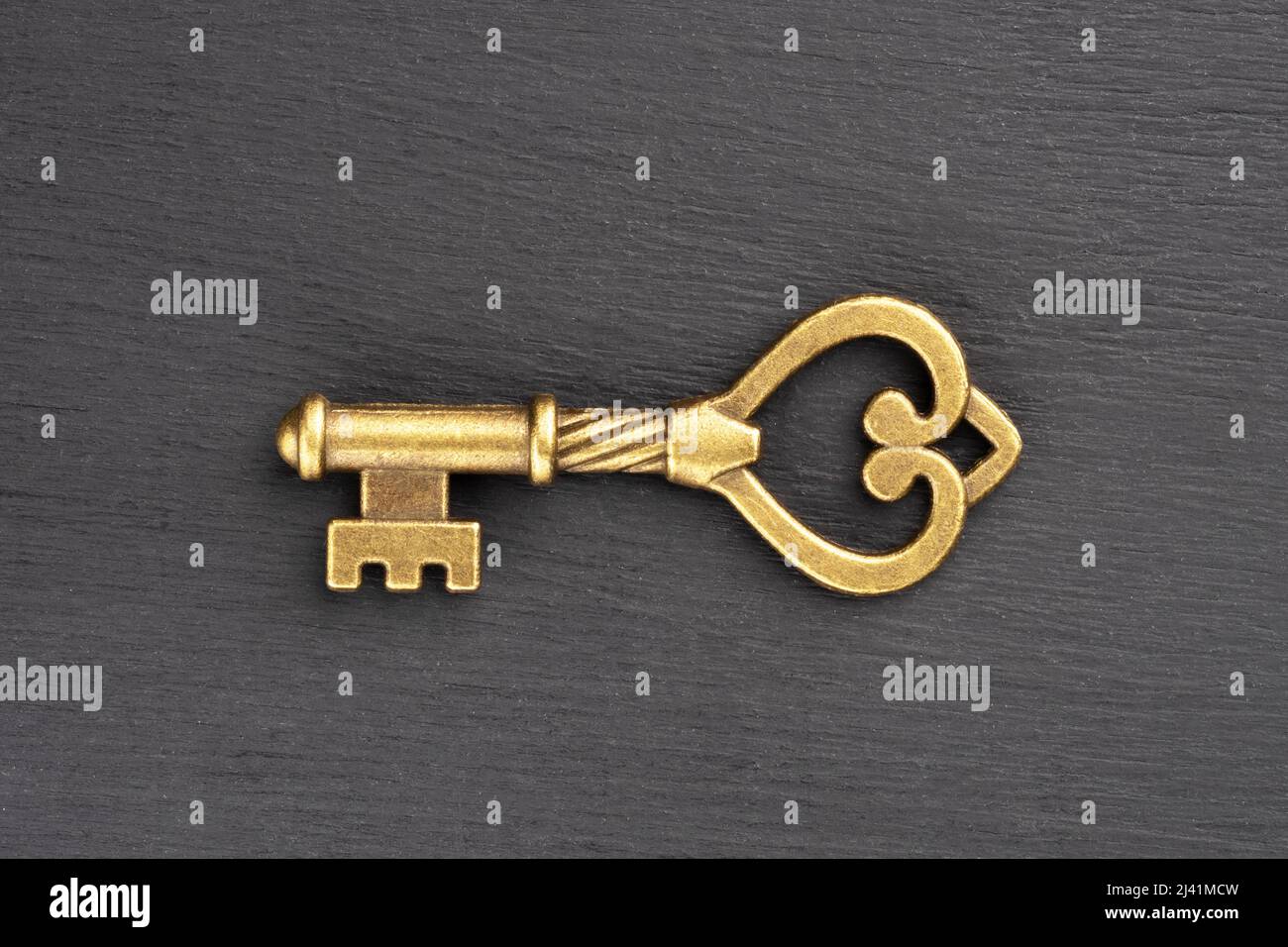 Bronze vintage antique key on black wooden background. Concept of ...