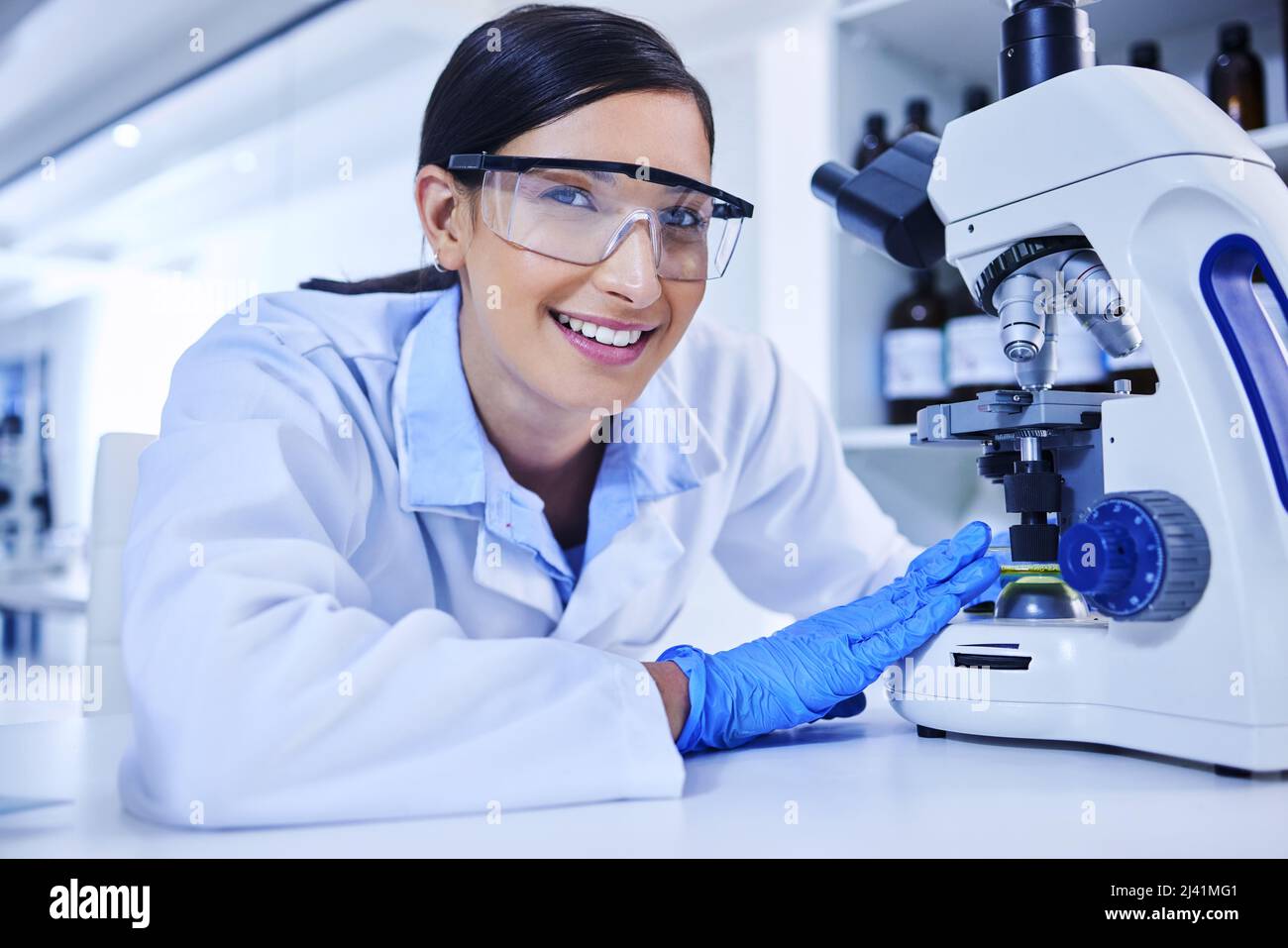 My trusty lab partner. Cropped portrait of an attractive young female scientist working with a ...