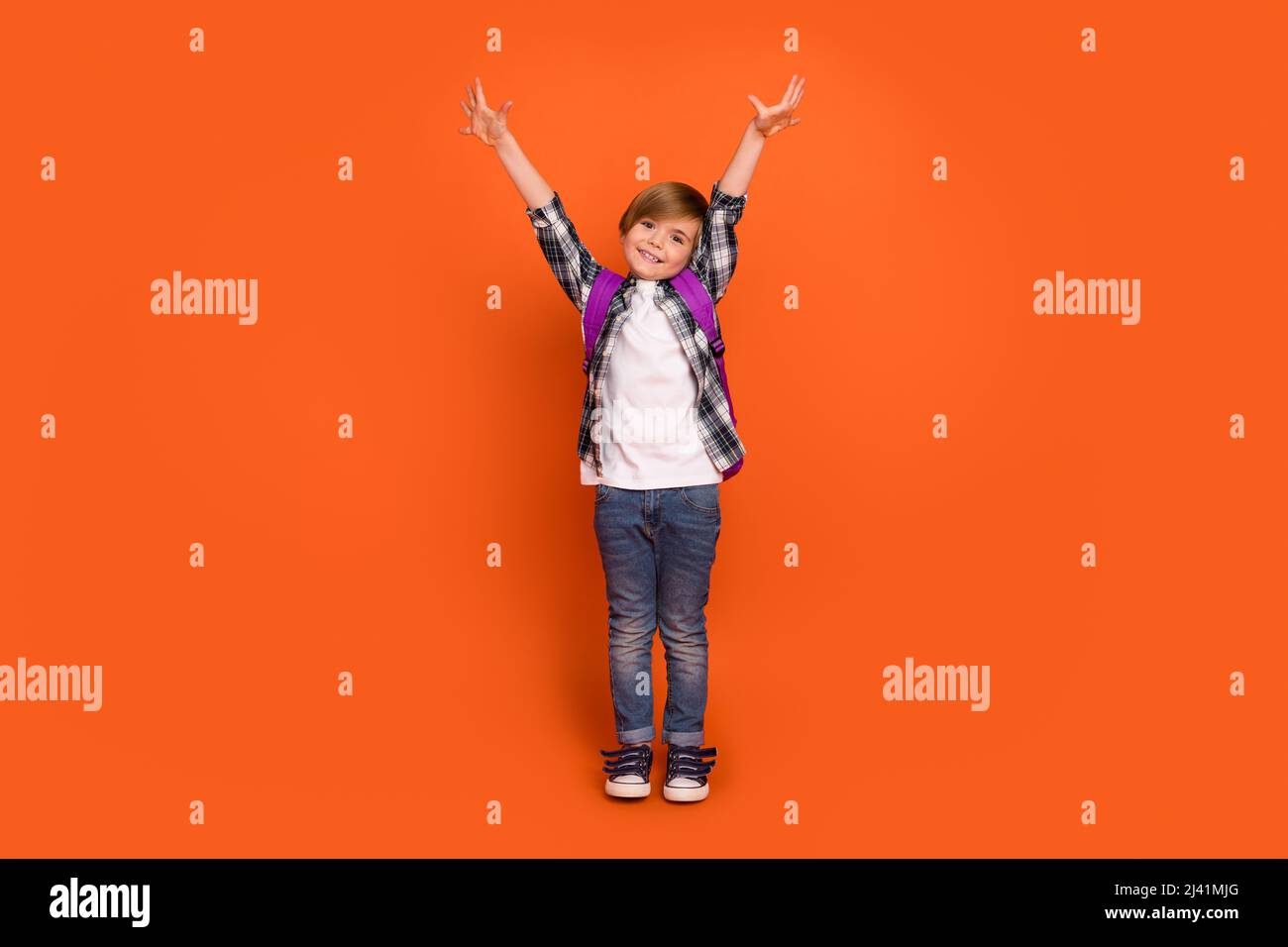 Full length photo of young cheerful boy good mood hold arms up isolated ...