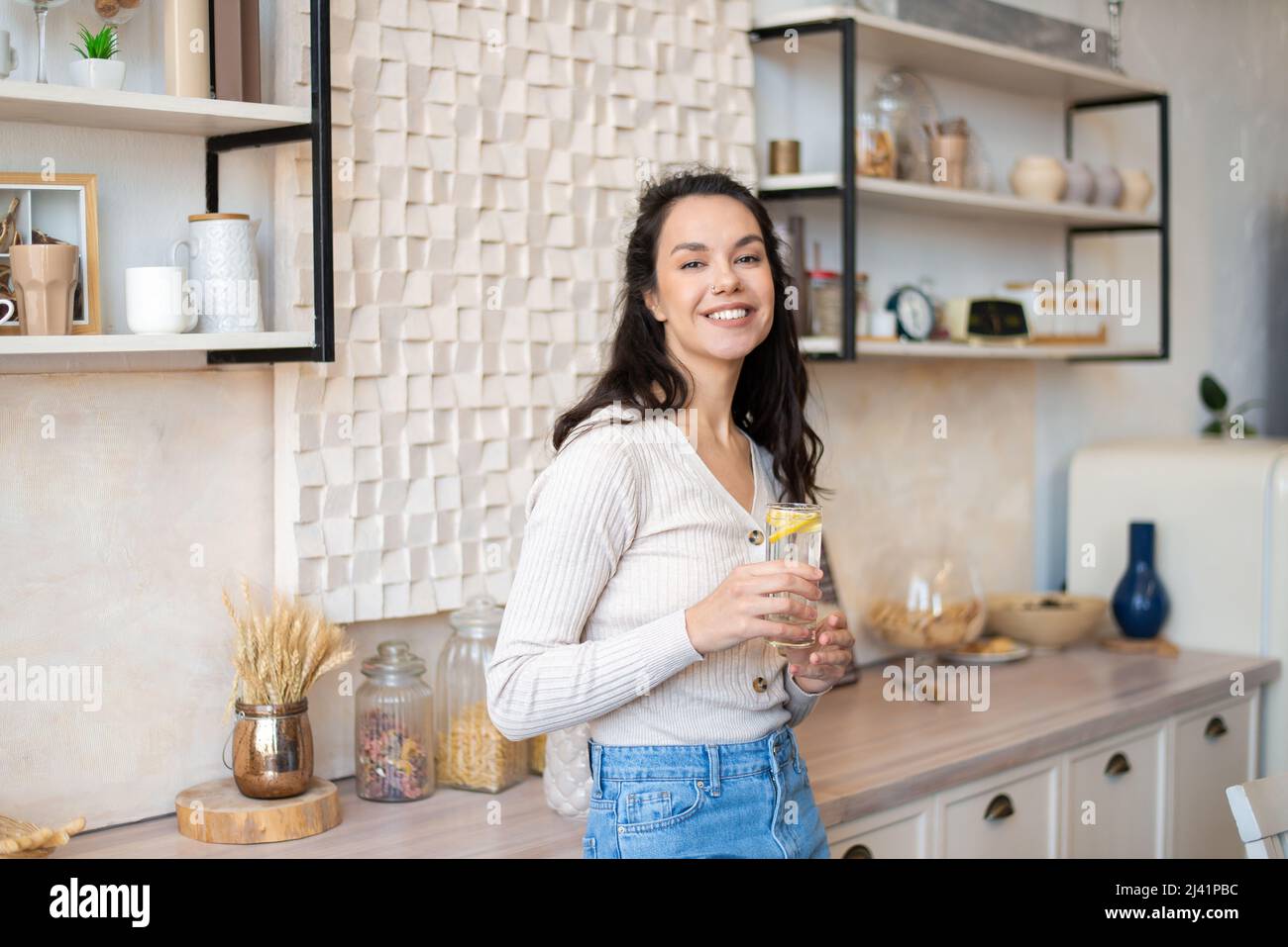 Healthy hydration concept. Happy lady drinking fresh water with lemon ...