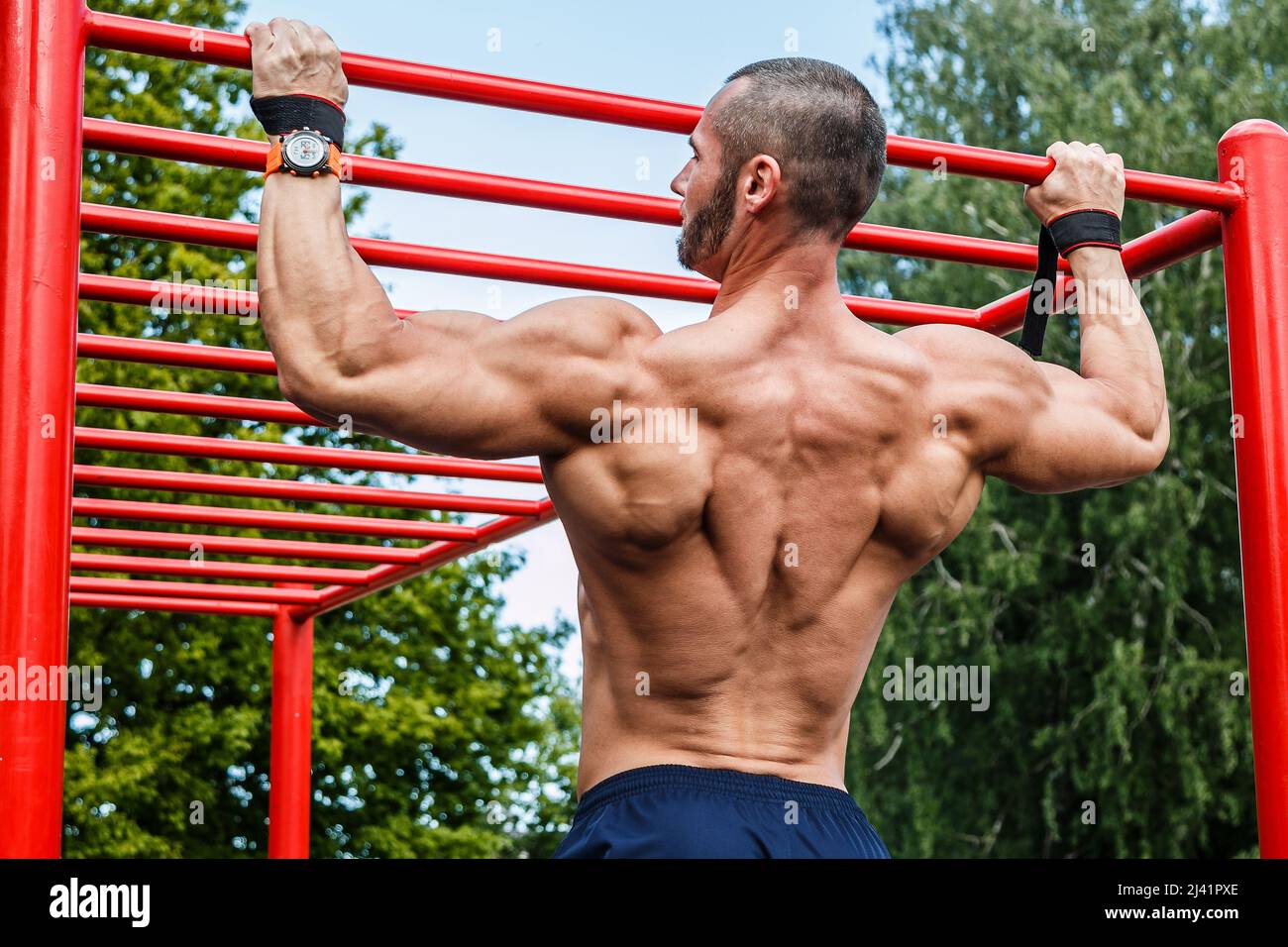 Muscular man doing pull-ups on horizontal bar Stock Photo - Alamy