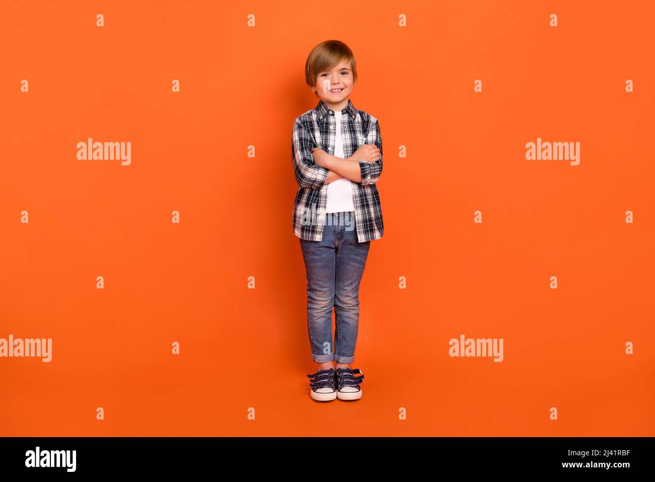 Full size photo of young cheerful school boy folded hands standing ...