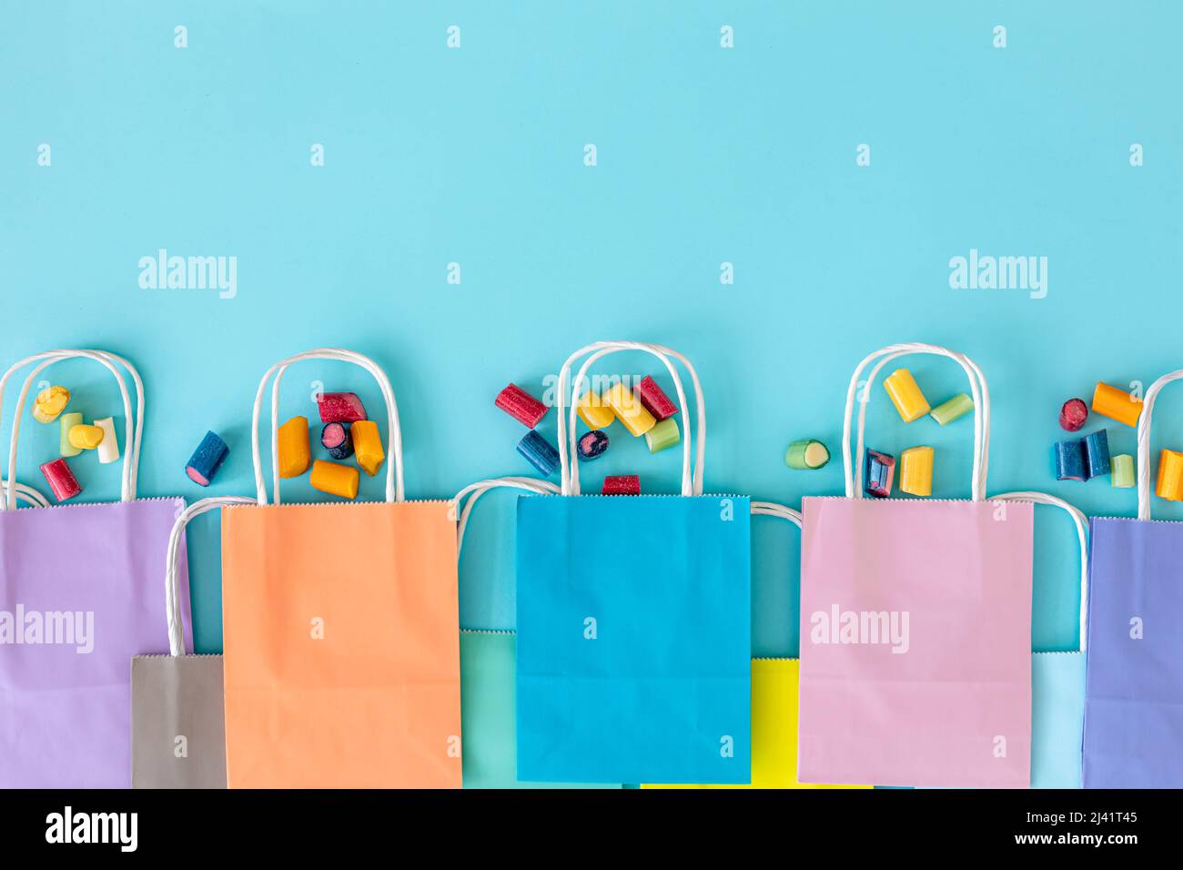 Flat lay, paper bags and chewing gummies on a blue background Stock ...