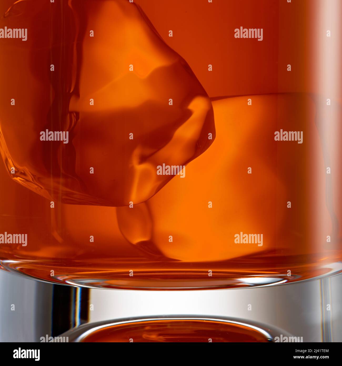 Macro view of an elegant whiskey with ice cubes in a glass. Hard drink ...