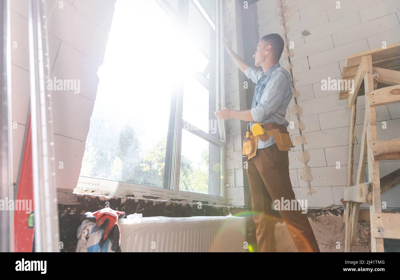 Construction worker installing window in house Stock Photo - Alamy