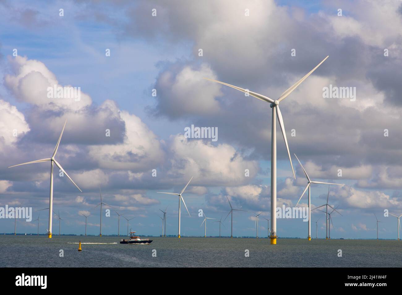 Aerial view of enormous windmills stand in the sea along a dutch sea ...