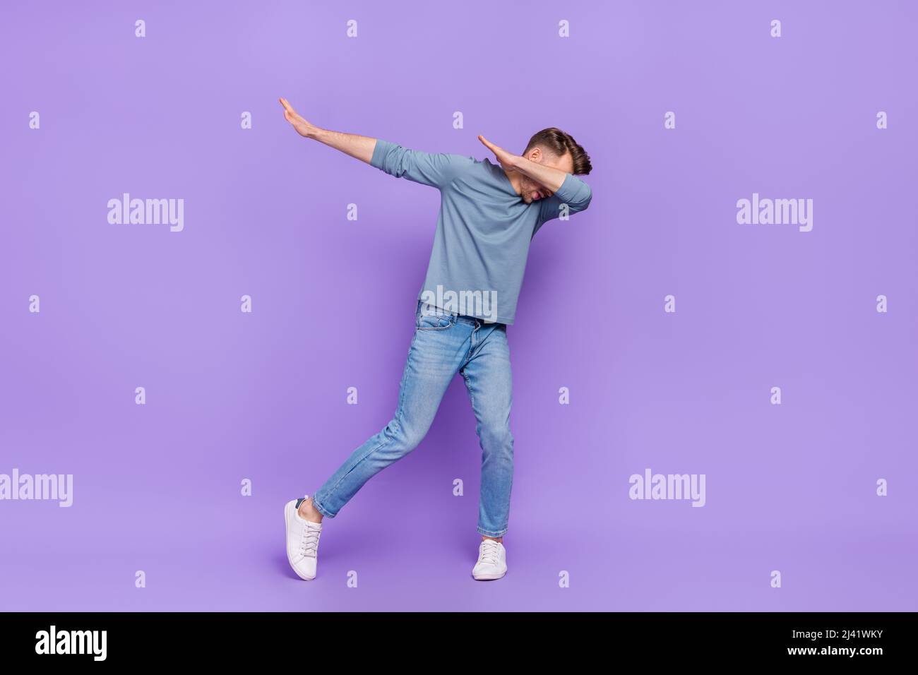 Photo of funny adorable guy wear grey shirt having fun dancing showing ...