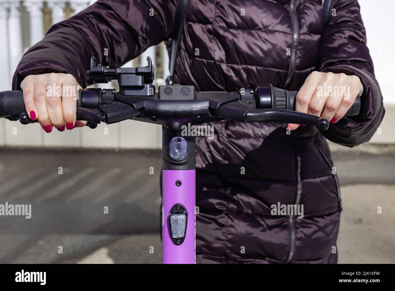a woman holding the steering wheel of a scooter with both hands. High ...