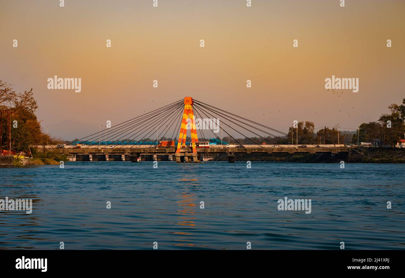 isolated cable bridge over ganges river with colorful sky at evening ...