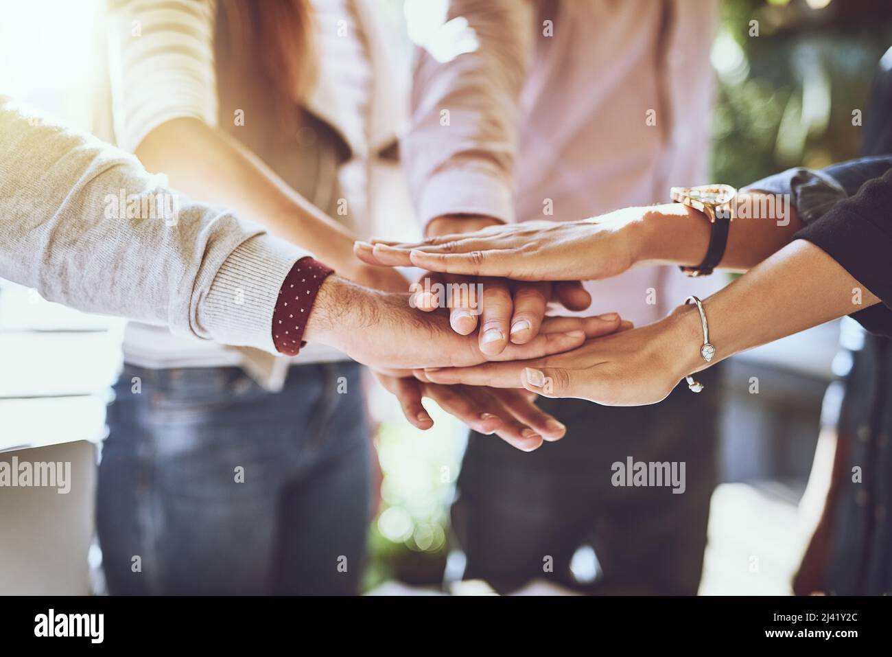 The power of togetherness. Shot of a group of colleagues joining hands ...