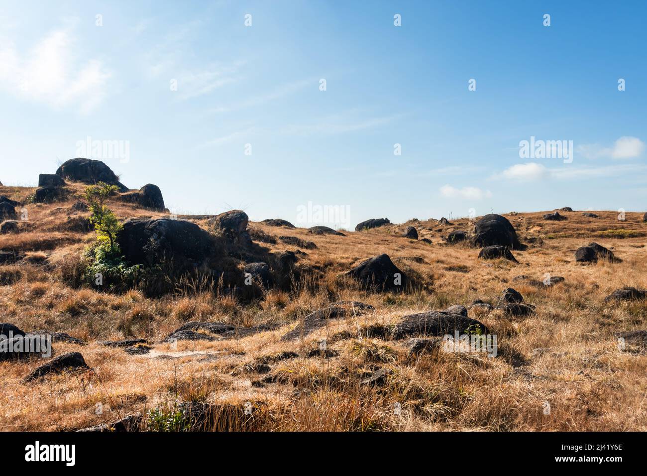 rocky yellow grass mountain with bright blue sky from flat angle image ...